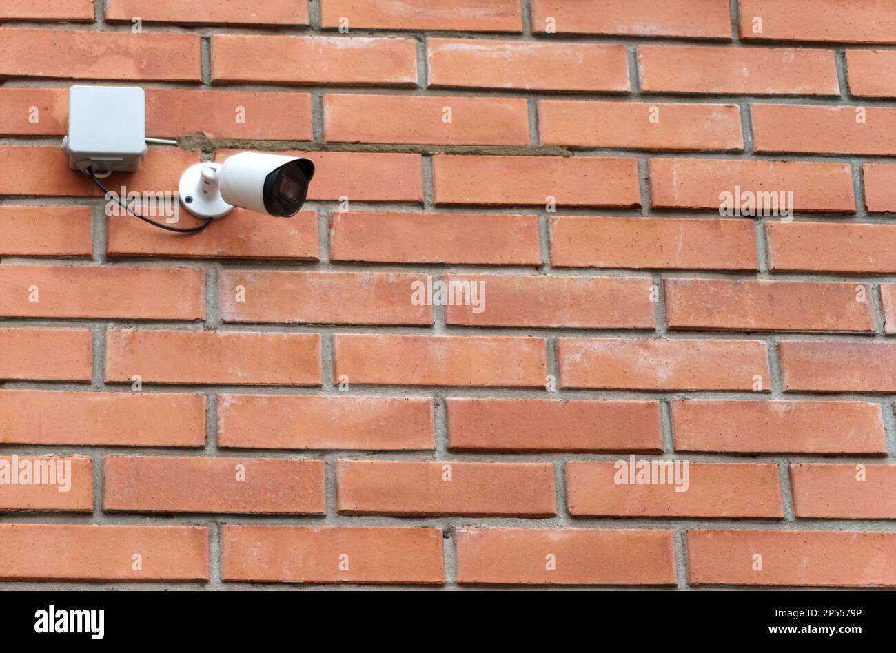 CCTV camera mounted on a brick wall, there is design space in front of ...