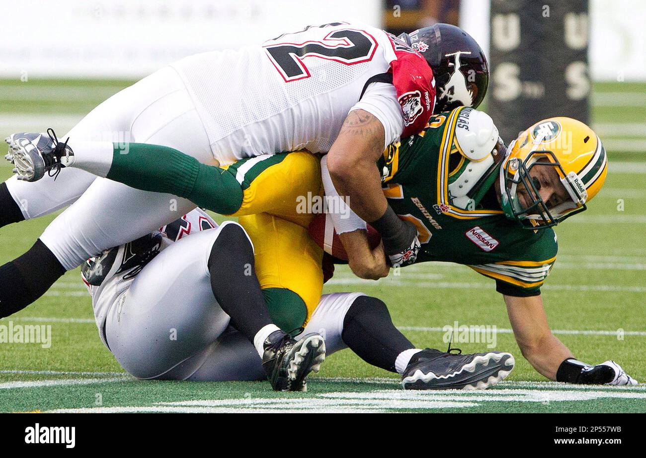 Calgary Stampeders Juwan Simpson (12) and Cordarro Law (49) sack Edmonton Eskimos quarterback ...