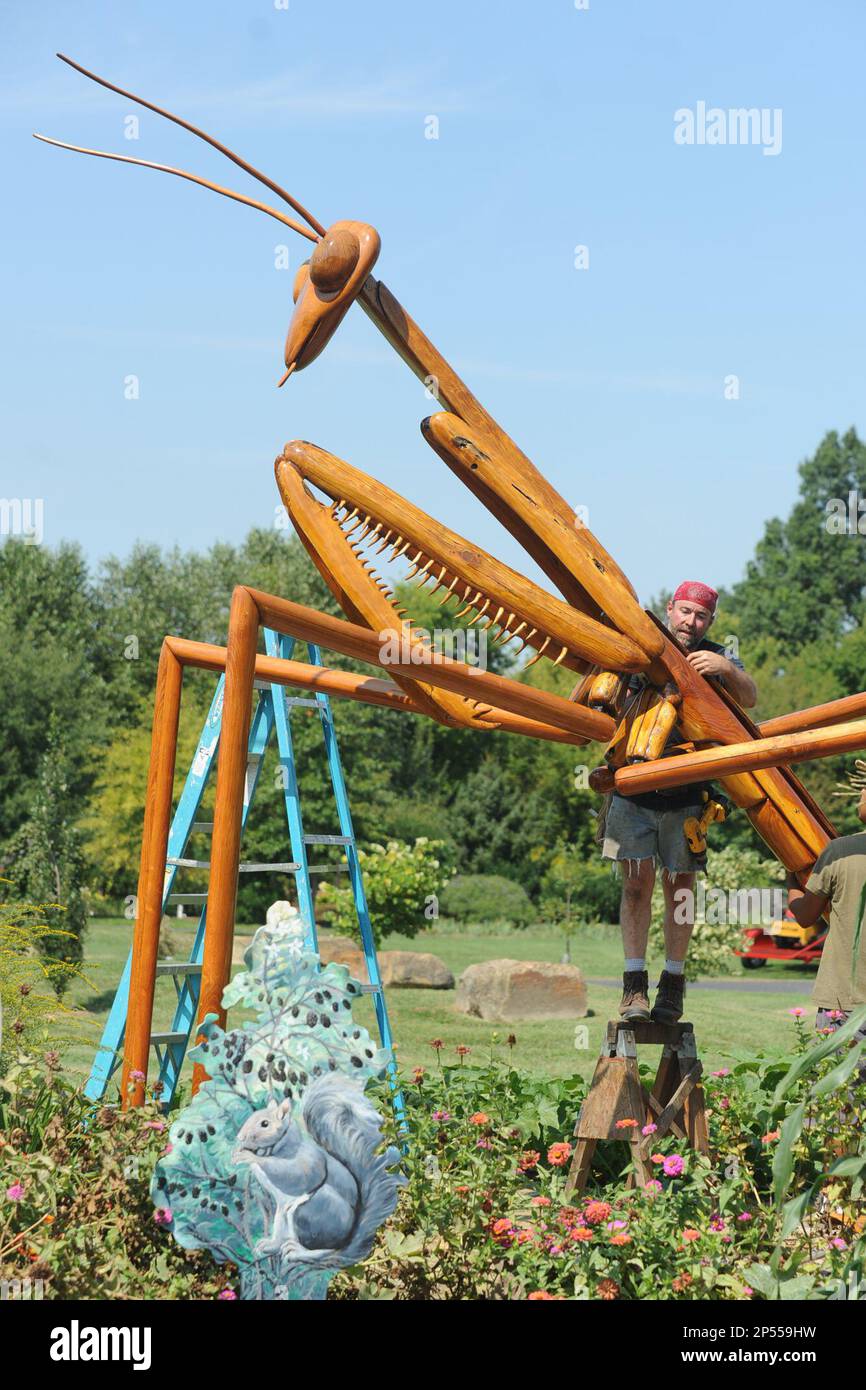 Artist David Rogers, of Glenwood Landing, N.Y., installs the wings on ...