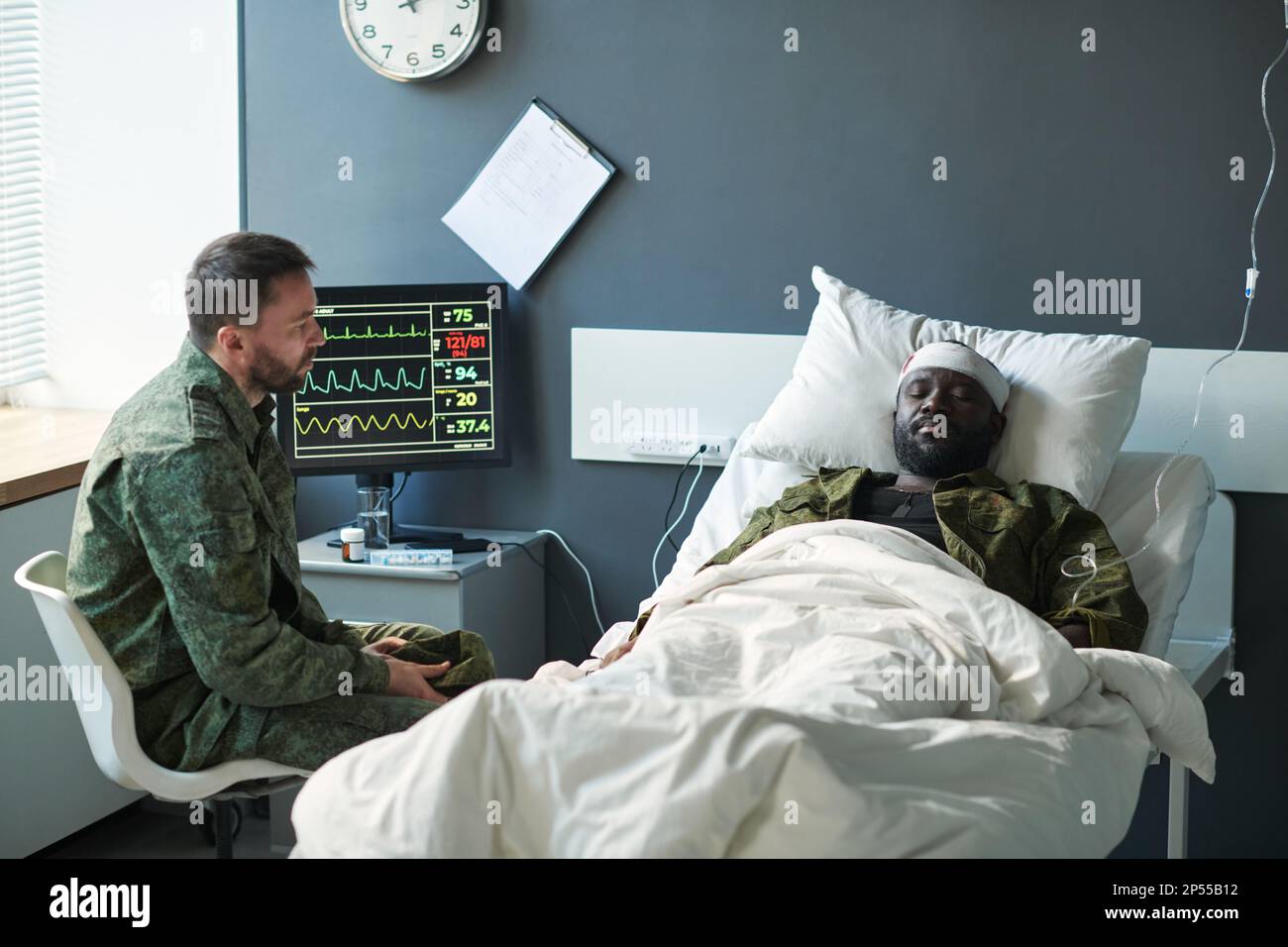 Injured African American soldier with bandaged head lying in bed in ...