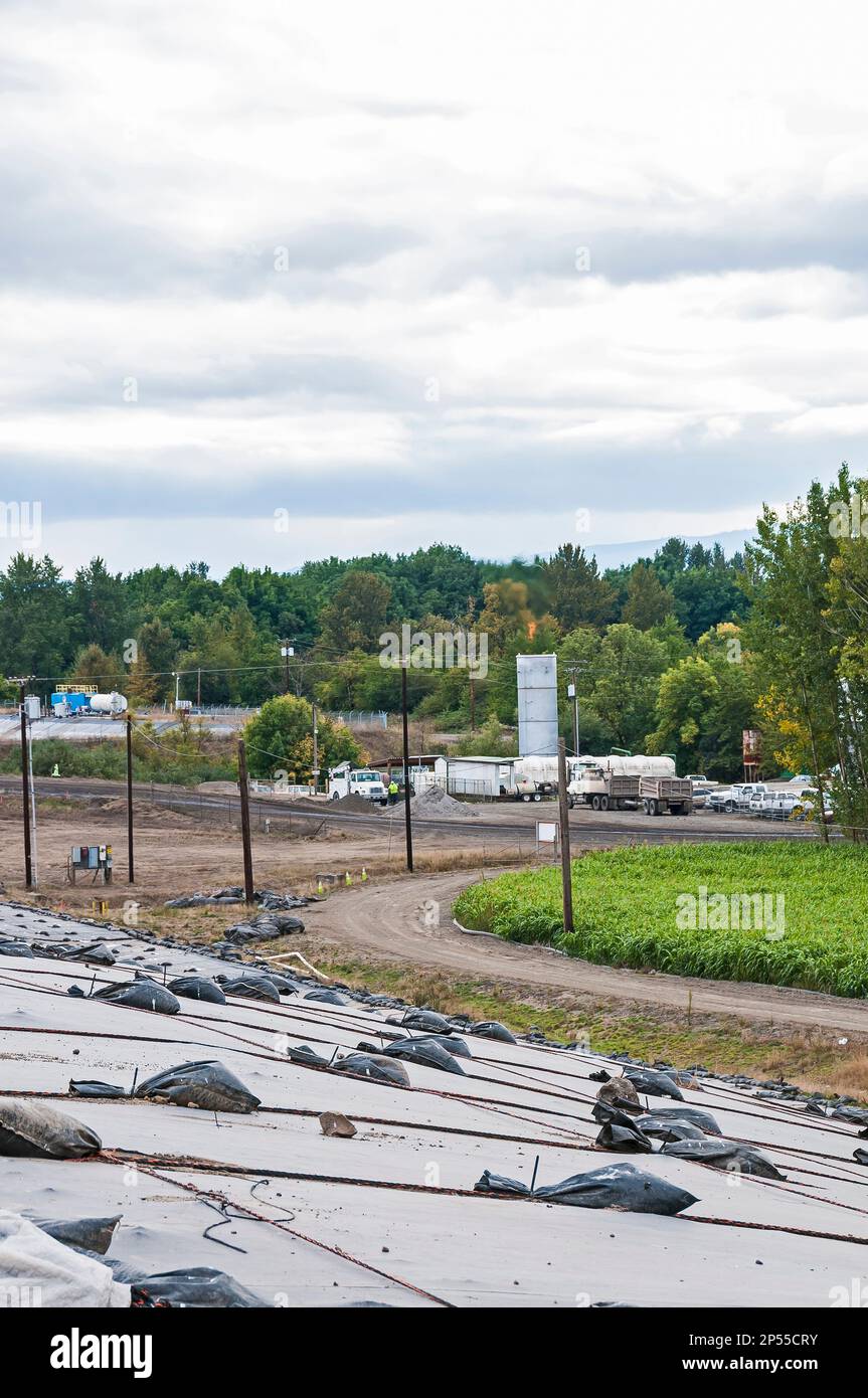 Weighted plastic sheeting covers a hillside in an active landfill ...