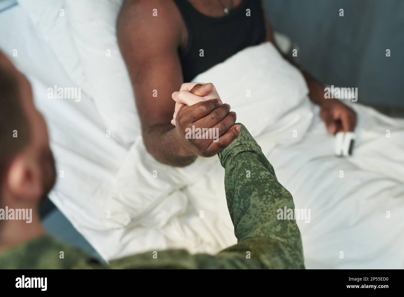High angle of handshake of African American injured soldier and his ...