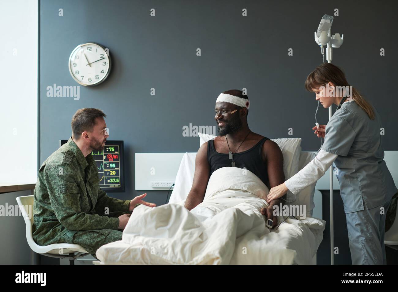 Young soldier in military uniform talking to his injured friend with ...