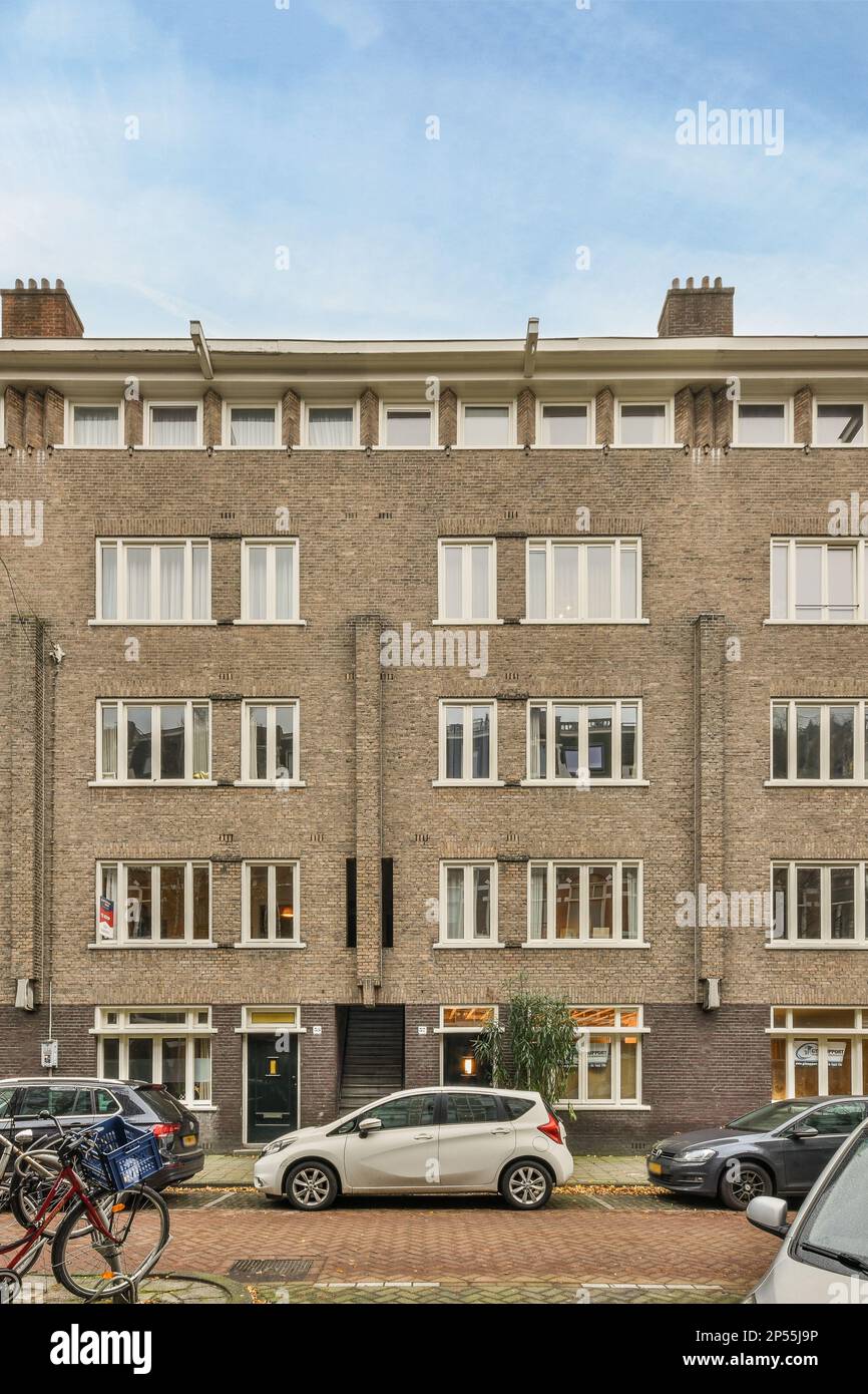 a brick building with cars parked on the street next to it and two ...