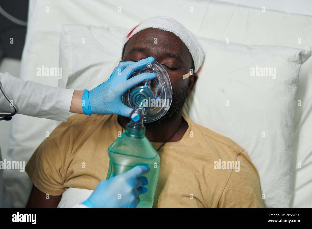Gloved hand of nurse or caregiver holding oxygen mask and balloon ...