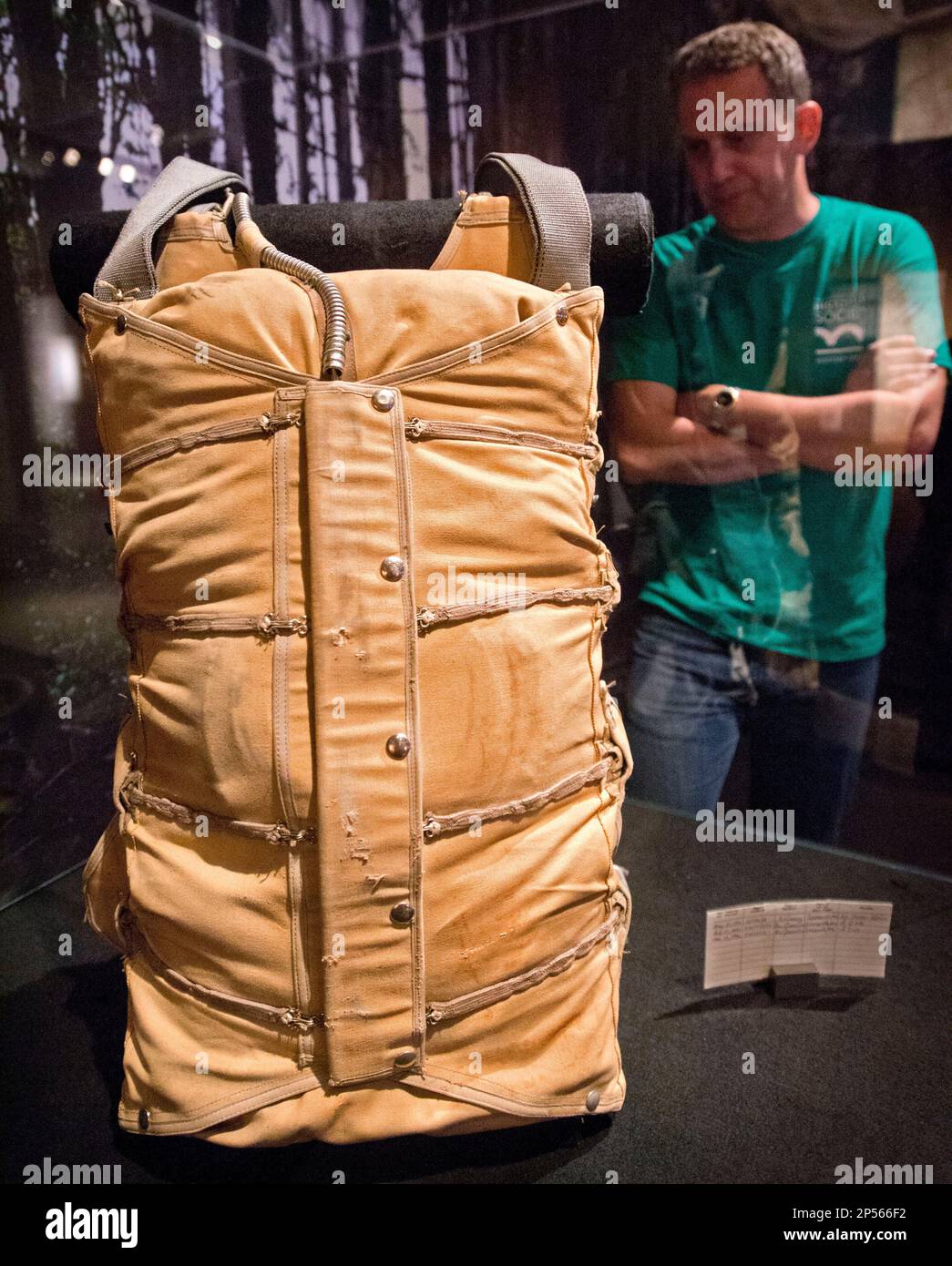 Museum curator Fred Poyner IV looks at one of 4 parachutes that was ...