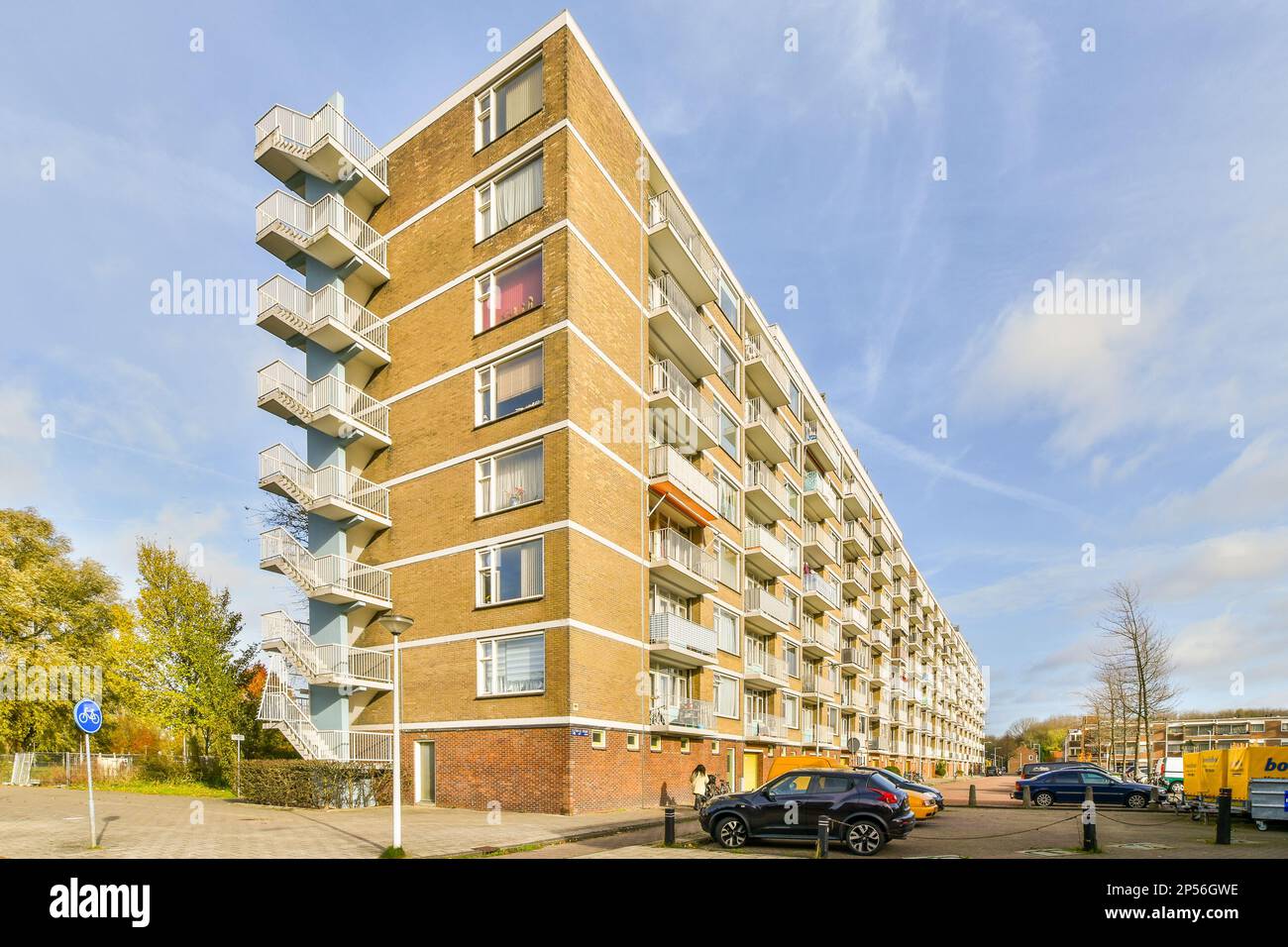 an apartment building with cars parked on the street next to it and ...