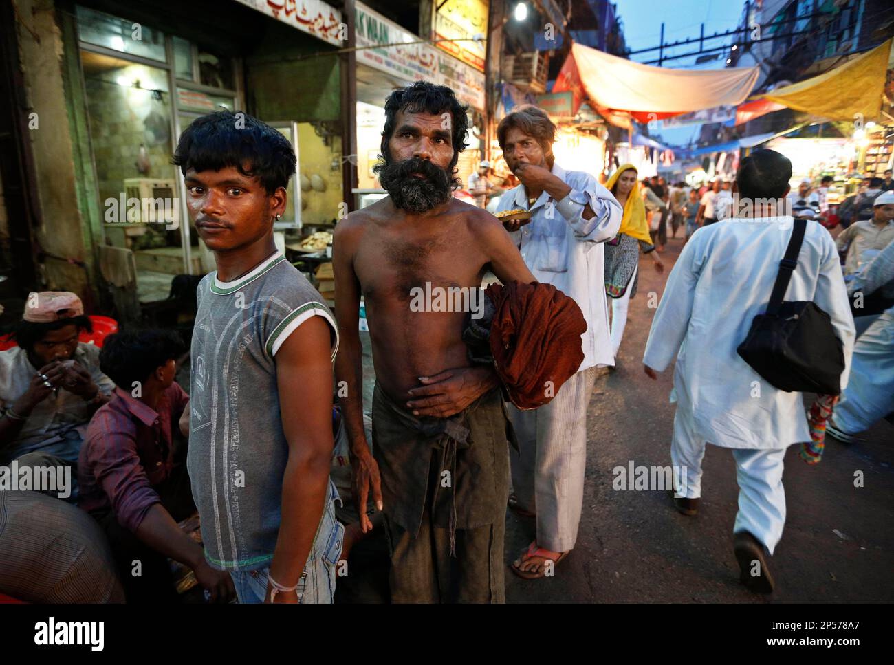 Homeless men wait for devout Muslims returning after offering their ...