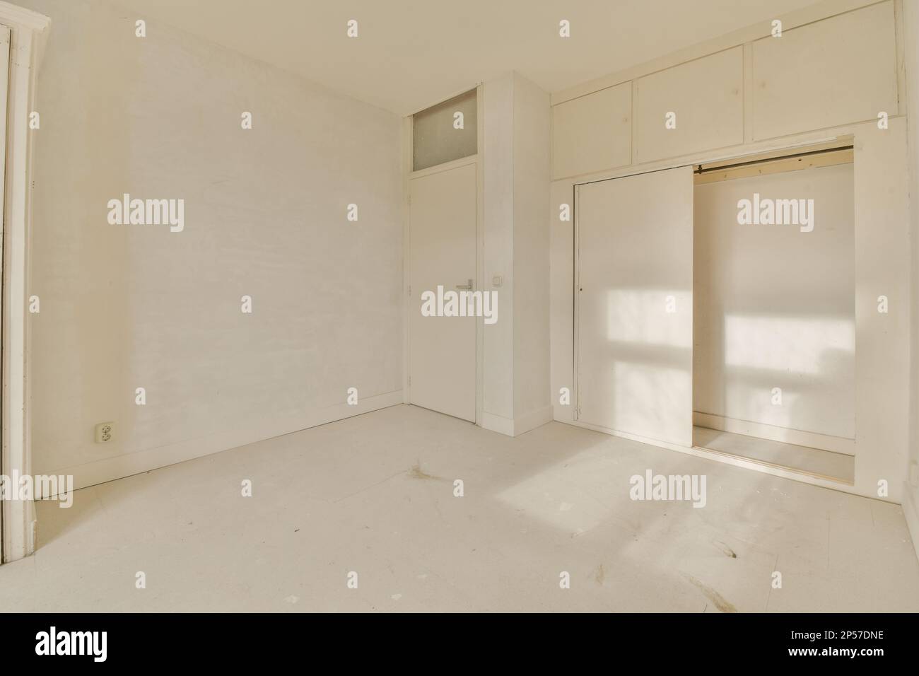 an empty room with white walls and cupboards on the wall, there is no ...