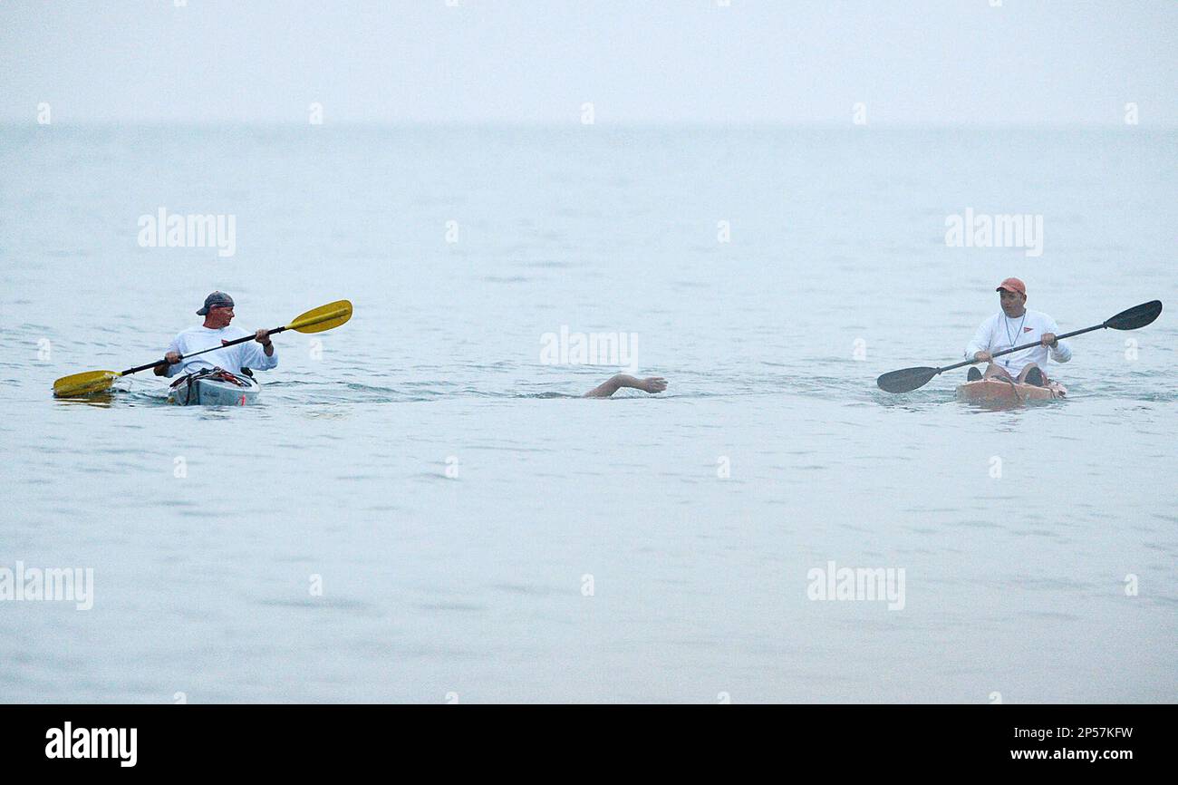 Mike Ferritto, center, of Wesleyville, swims across Lake Erie toward ...