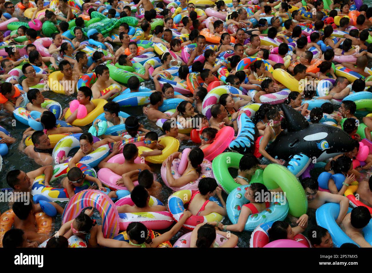 In this July 27, 2013 photo, people crowd into a saltwater swimming ...