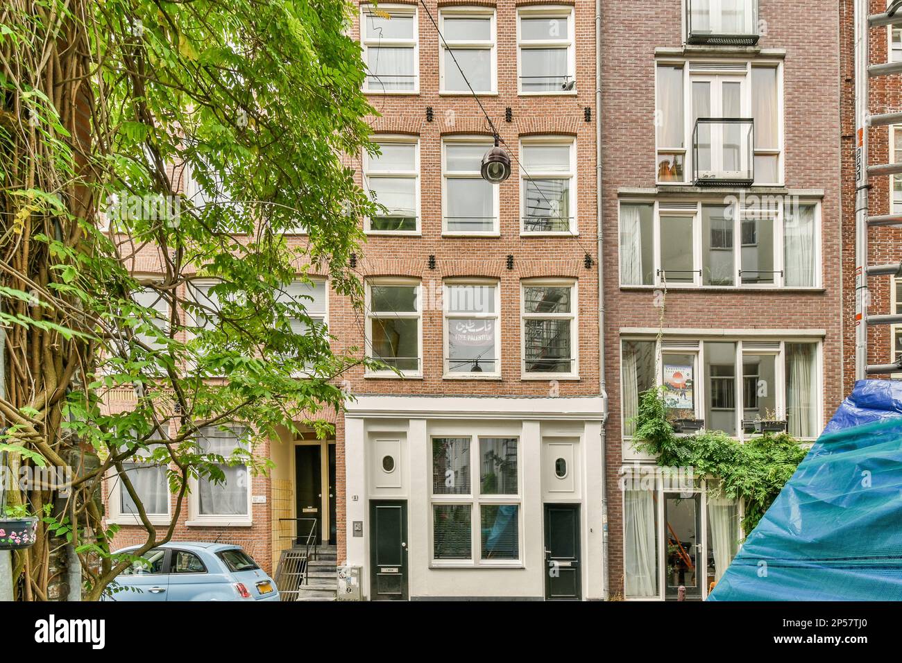 a city street with cars parked in front of the apartment buildings and ...