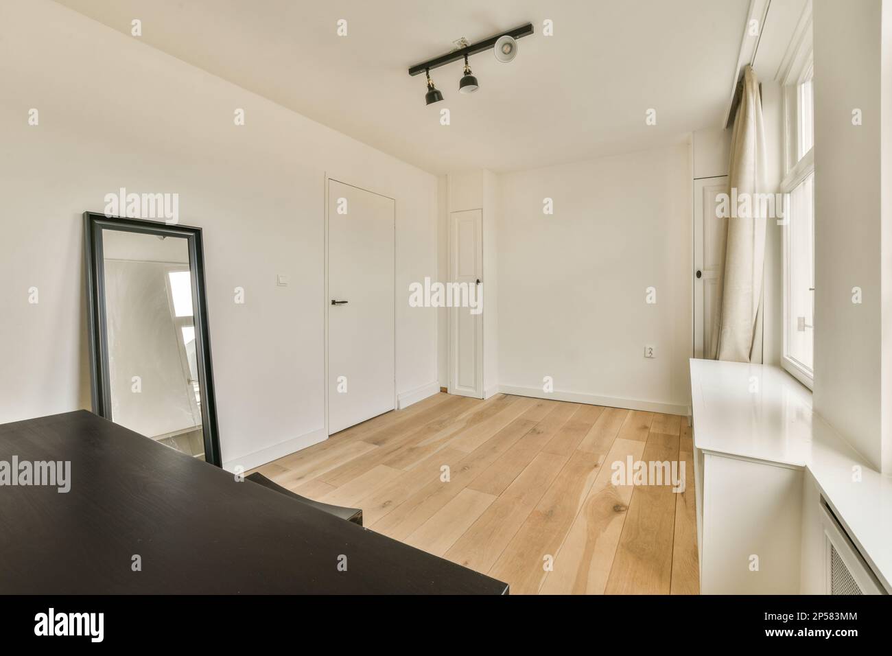 an empty room with white walls and wood flooring on the right side ...