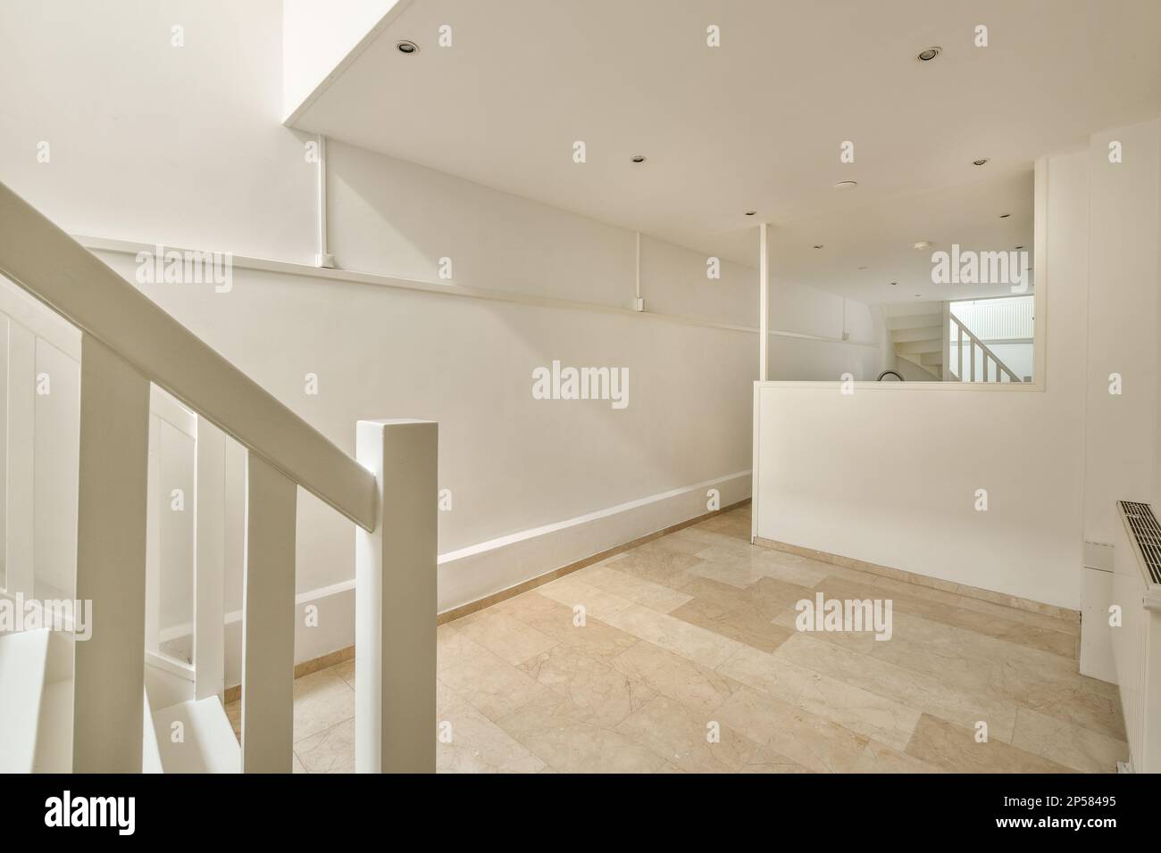 an empty room with white walls and wood stairs leading up to the second ...