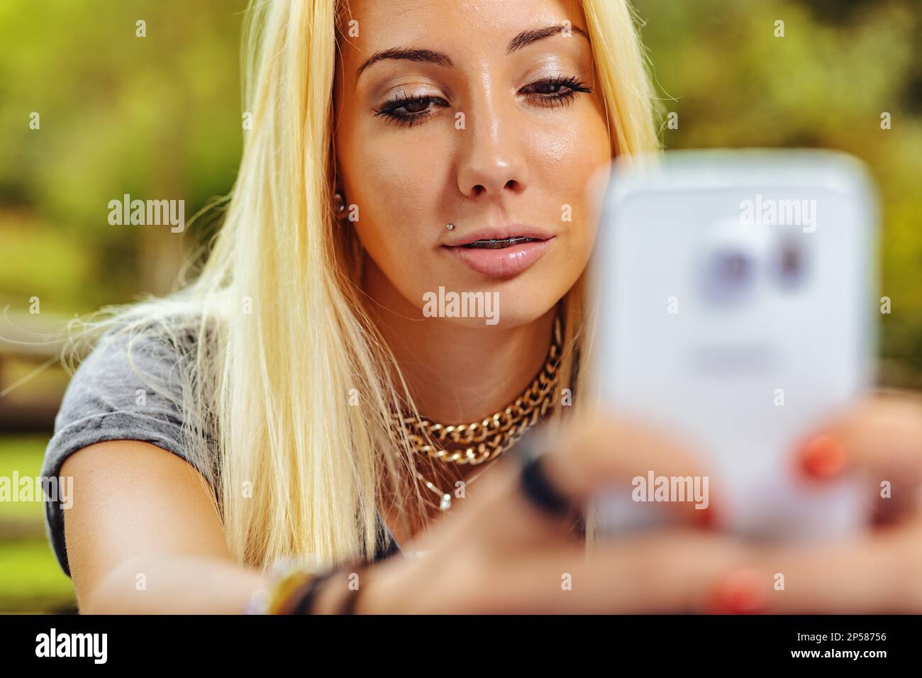 Beautiful Blond Girl In An Outdoor Forest Or Public Park On A Sunny Day She Has Very Visible