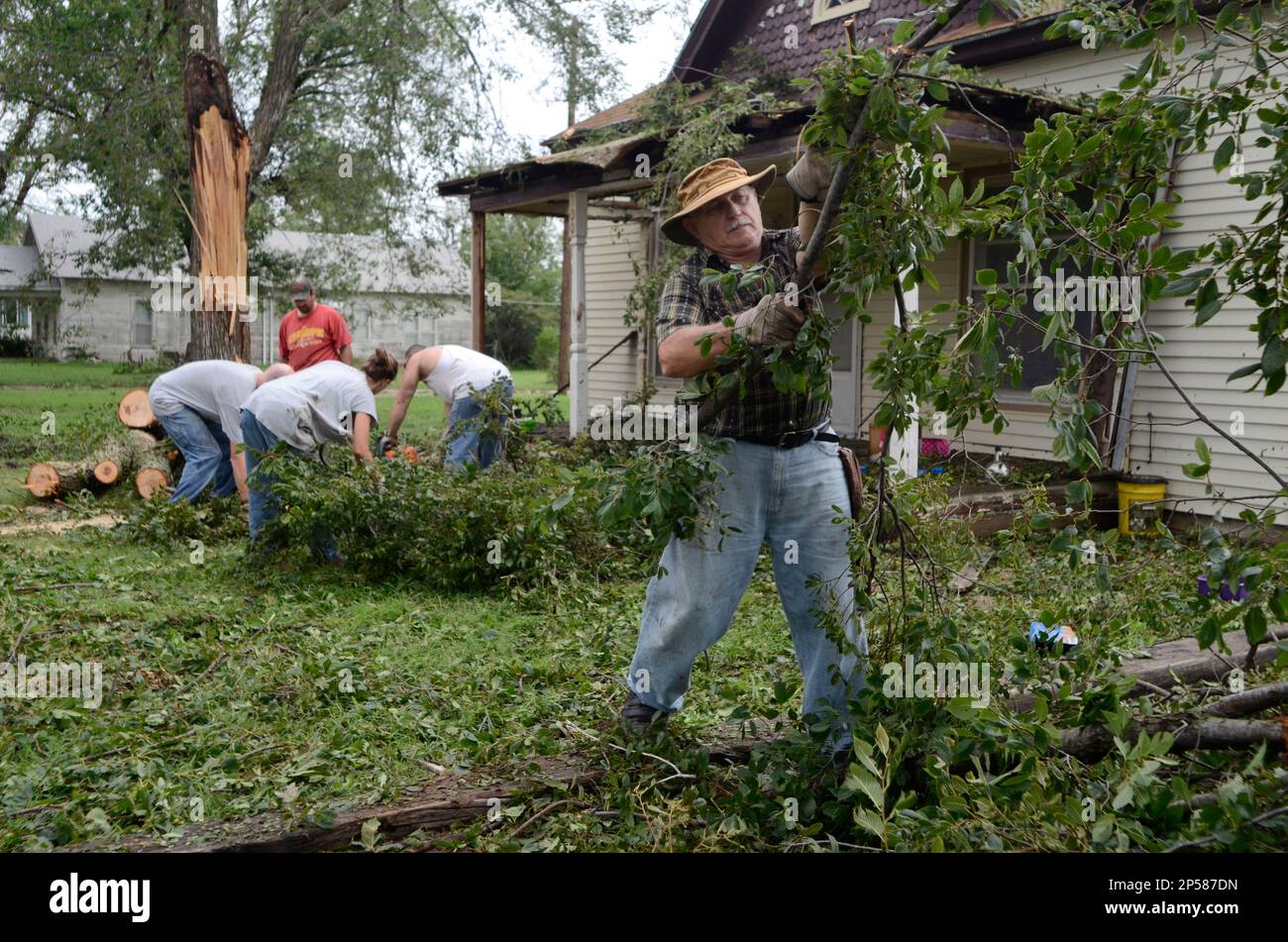 Jim White and other volunteers pick up tree branches and debris ...