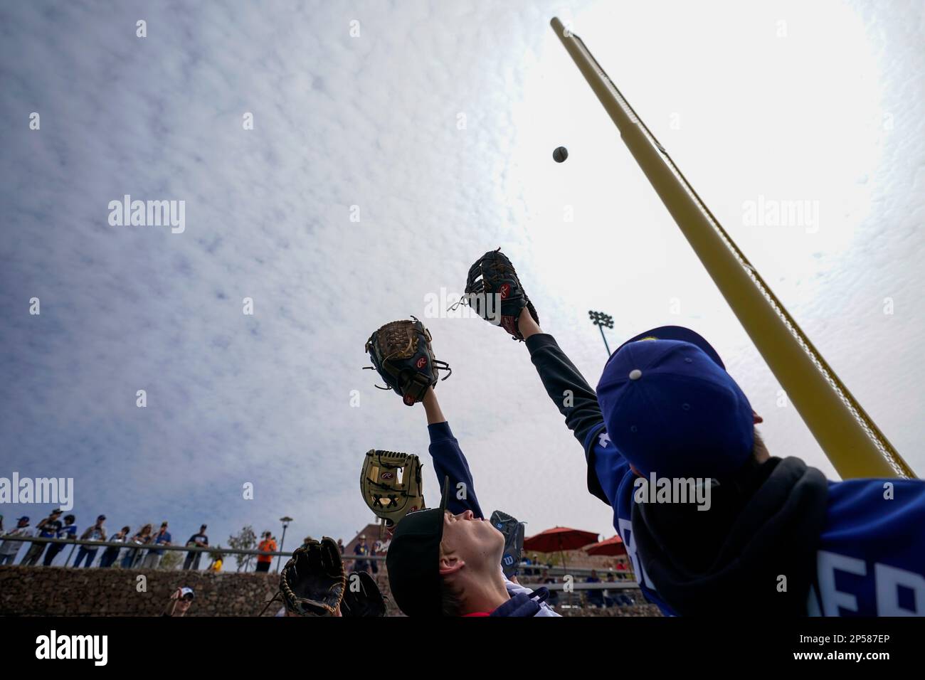 Fans reach for a ball thrown in to the crowd before a spring training ...