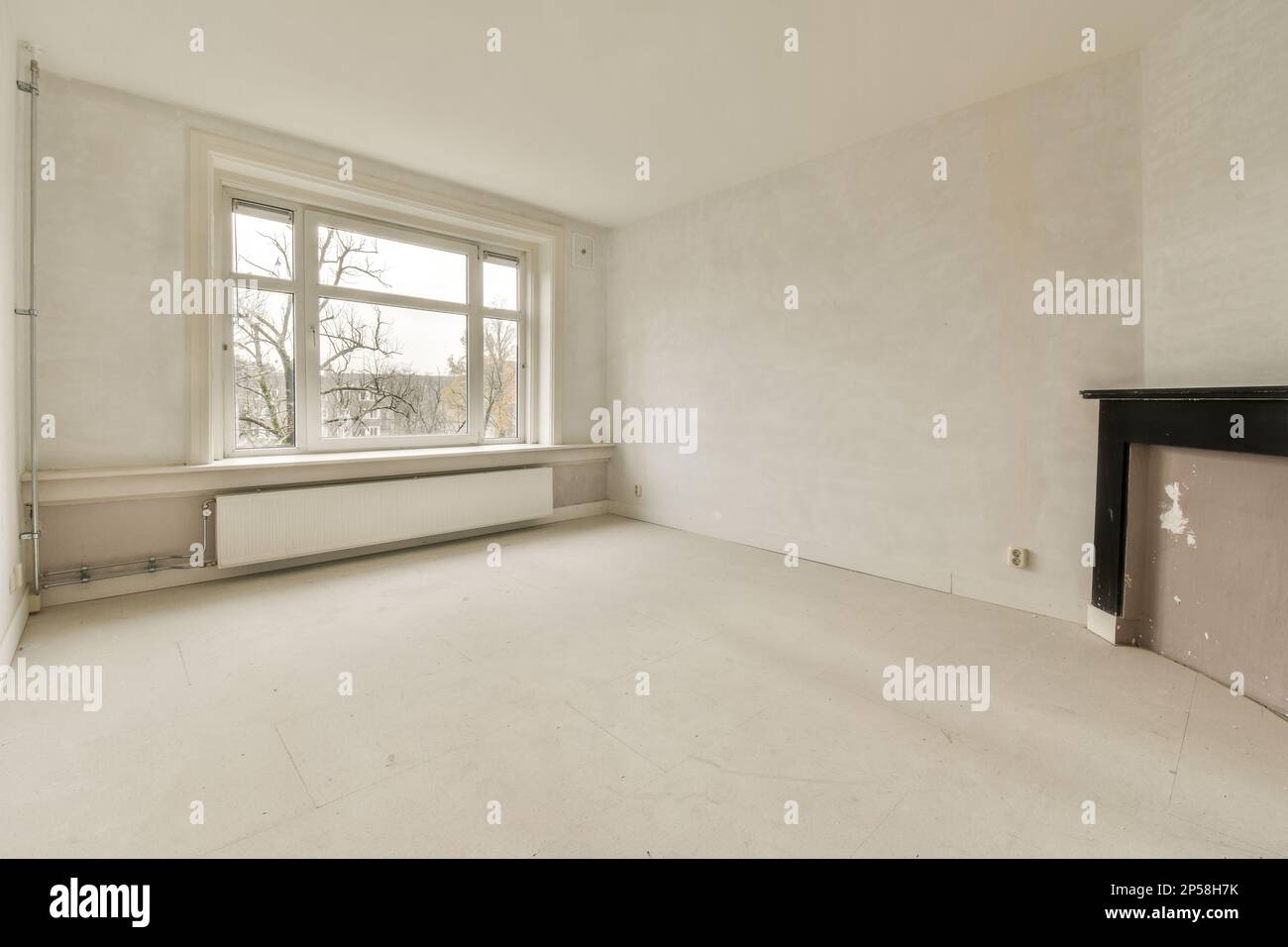 an empty room with a fire place in the corner and no one on the floor ...