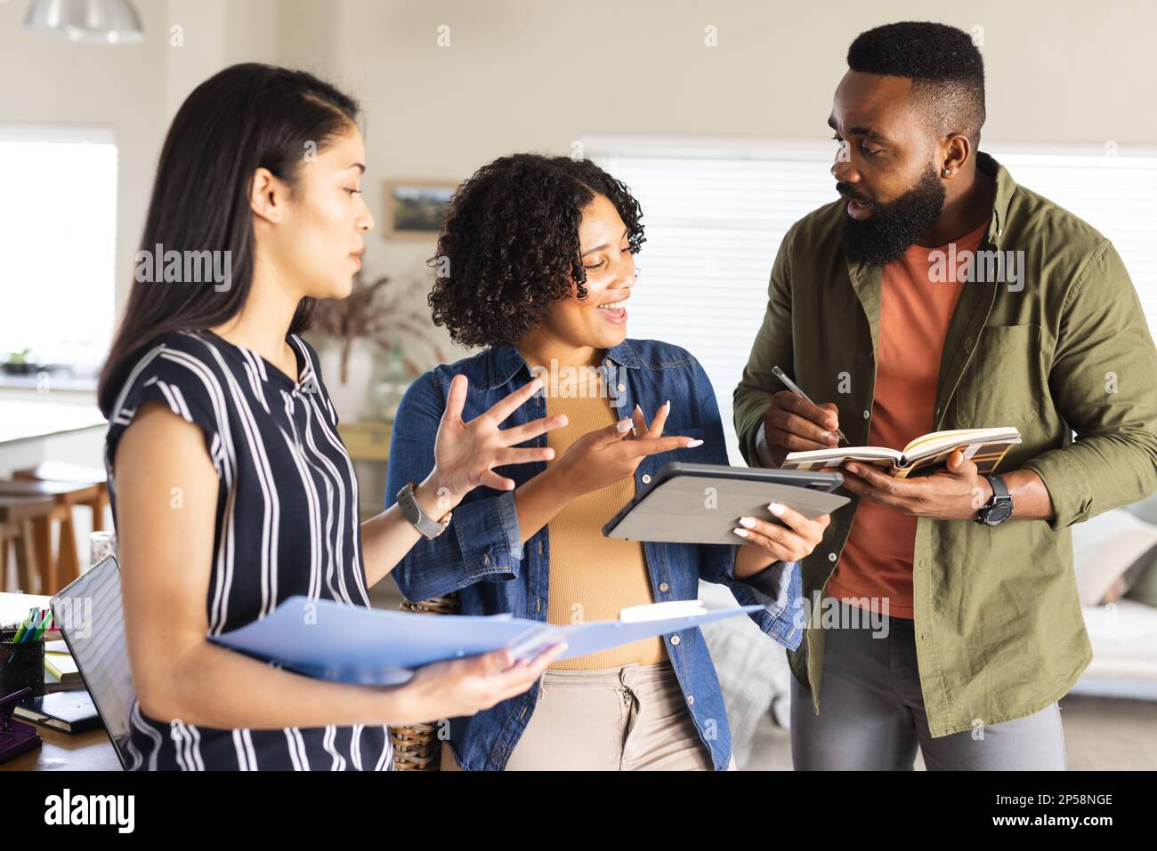 Happy diverse friends working together at home, using tablet Stock ...