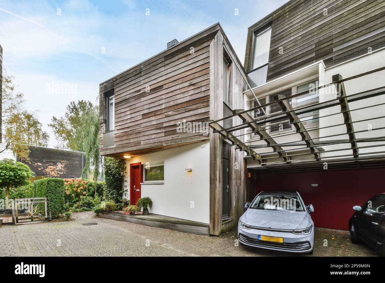 two cars parked in front of a house with wood sidings on the side and ...