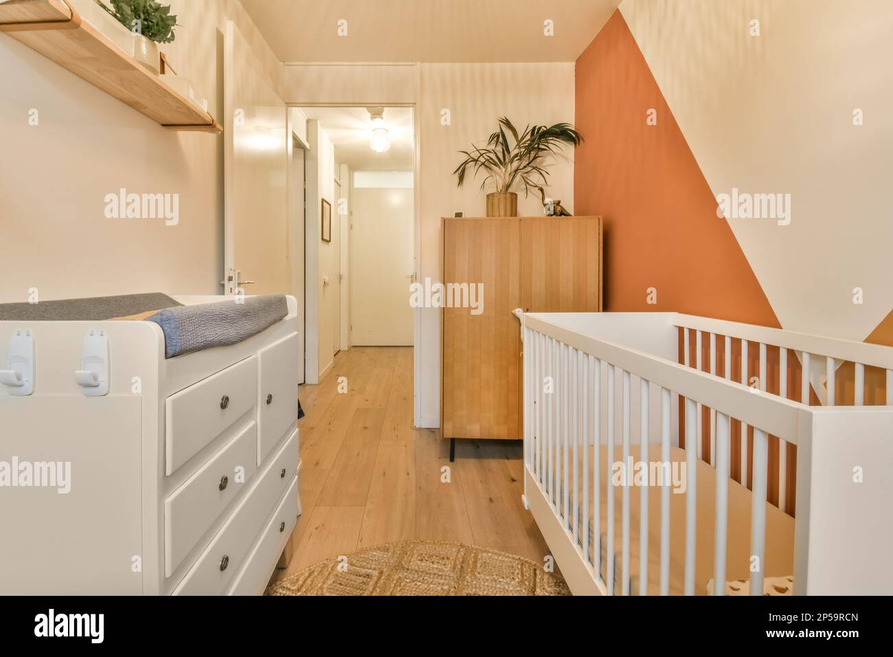 a baby's room with an orange accent wall and white cribe furniture in ...