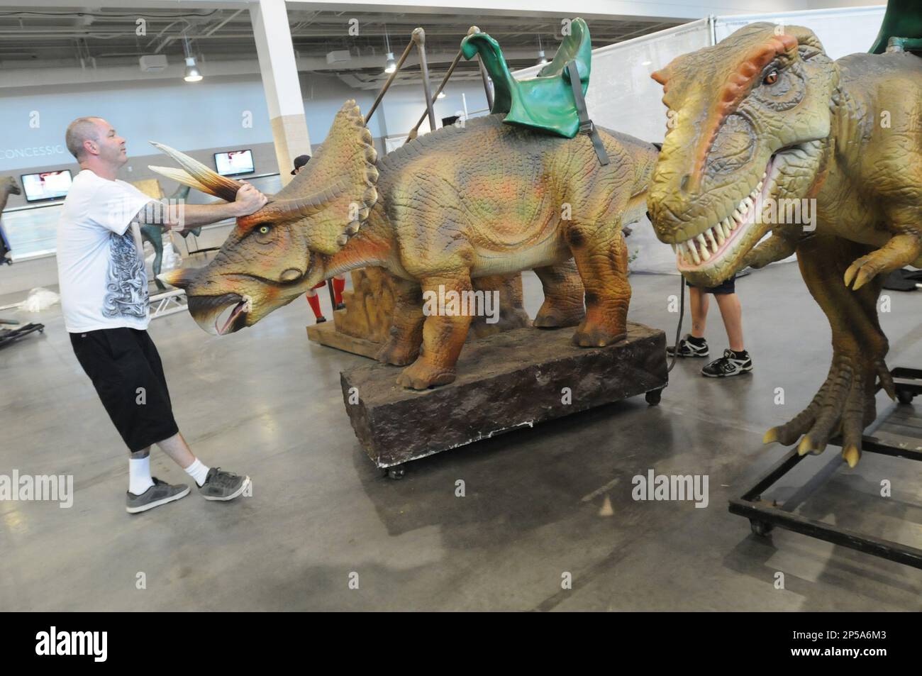 Stacy Mills with Blue Star Productions positions a model of a dinosaur ...