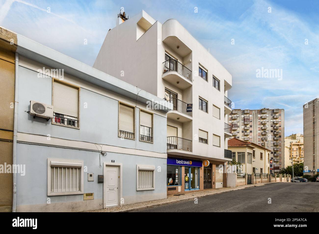 a city street with buildings in the background and cars parked on the ...