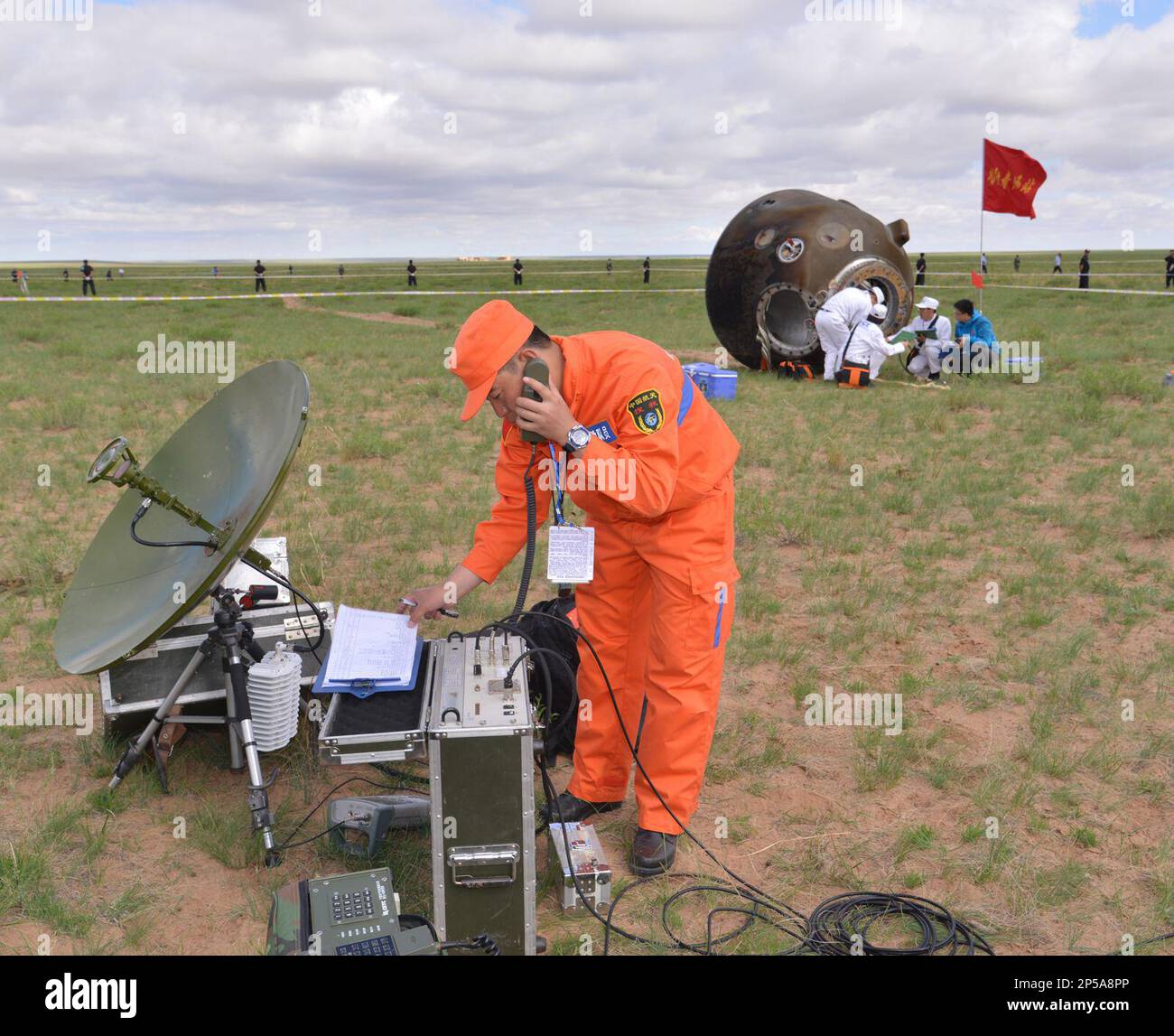 Ground crew check the re-entry capsule of Shenzhou 10 spacecraft after its landing at the main ...
