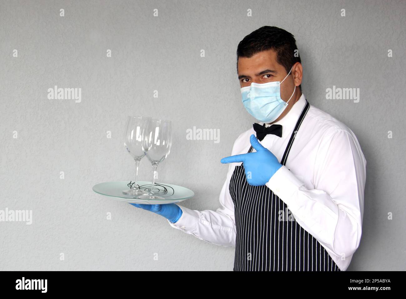 Latin bartender somelier with red wine, face masks and latex gloves ...