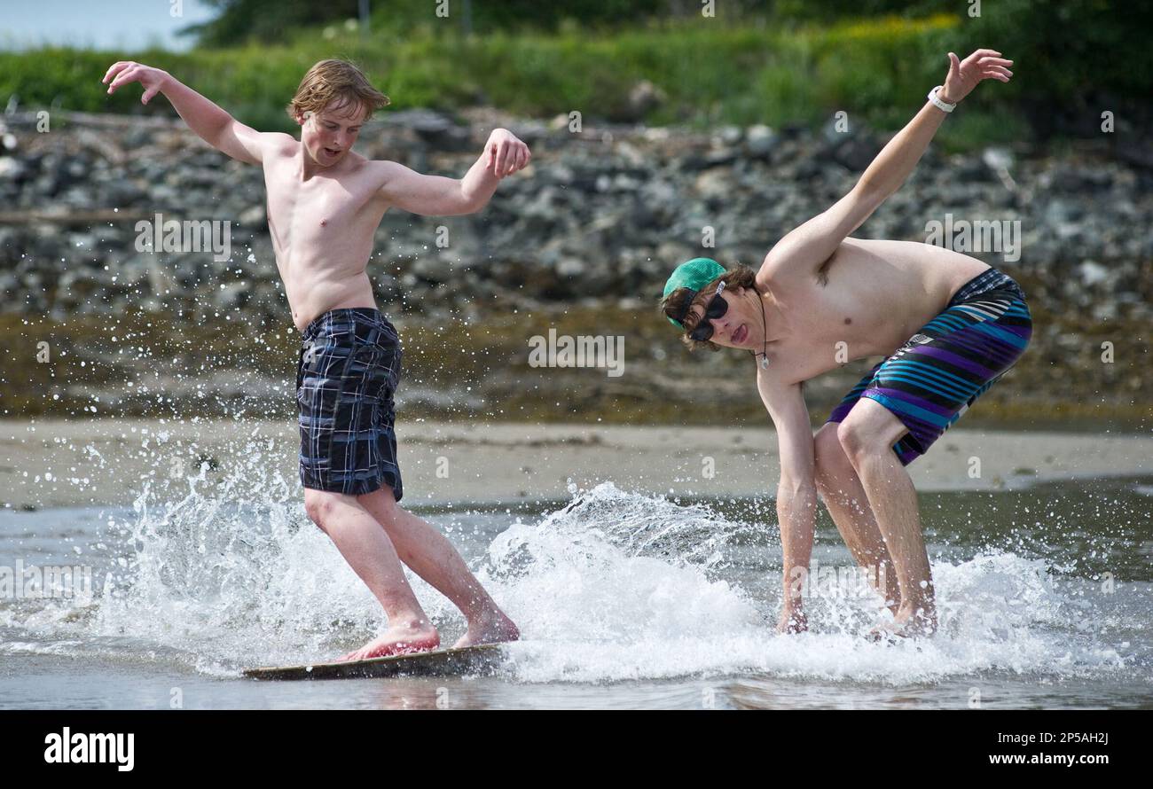 Jacob Fisher, left, and Jacob Eberhardt, both 16, work on their skimboarding skills at Sandy ...