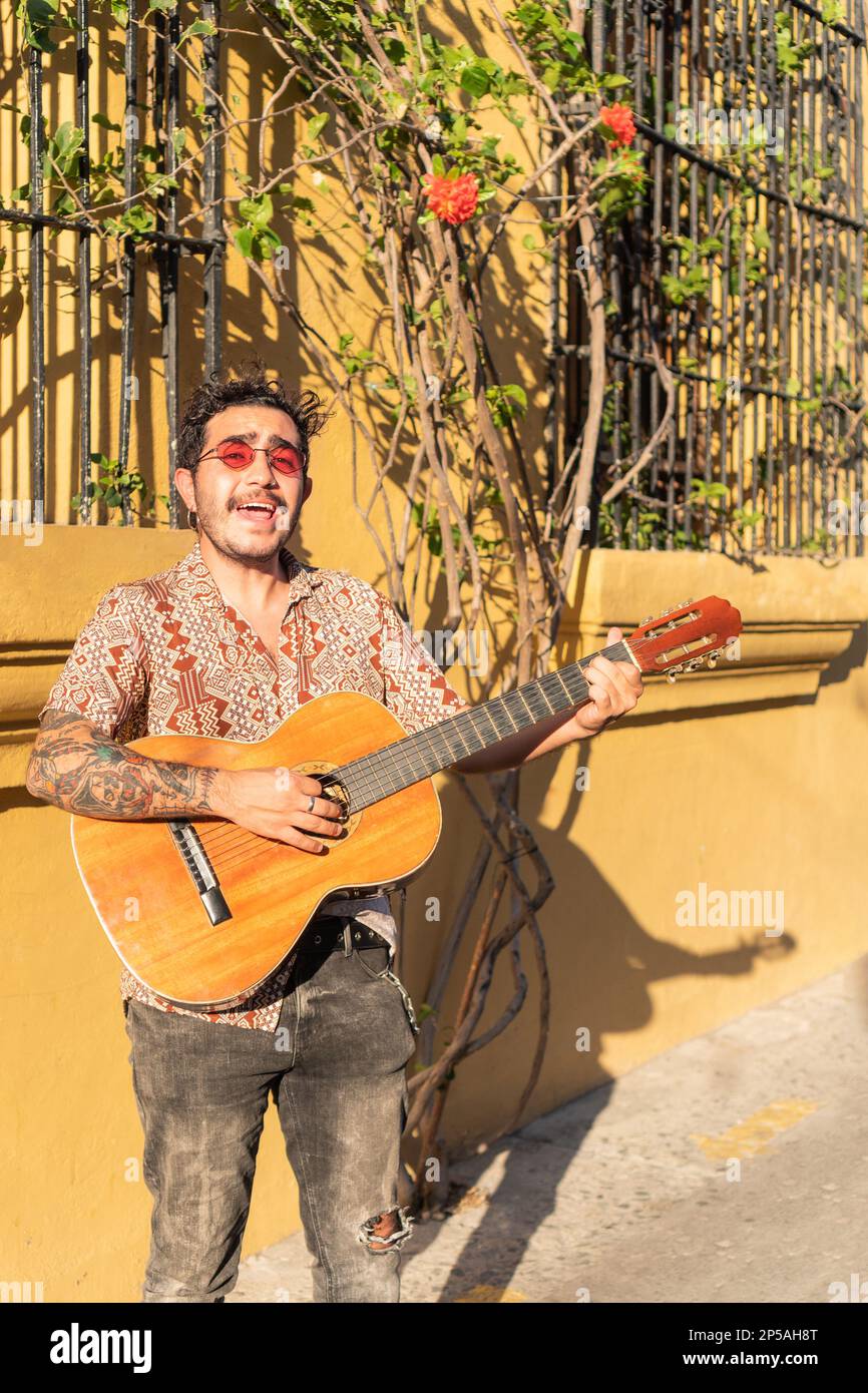 Latin musician playing guitar standing on the street Stock Photo - Alamy