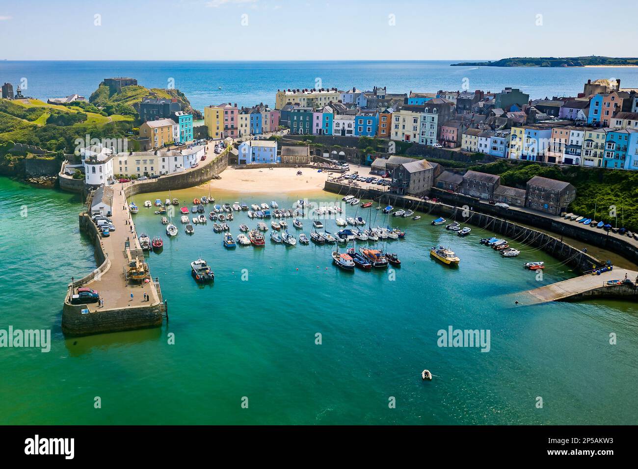 Aerial view of brightly colored buildings around a small harbour (Tenby ...