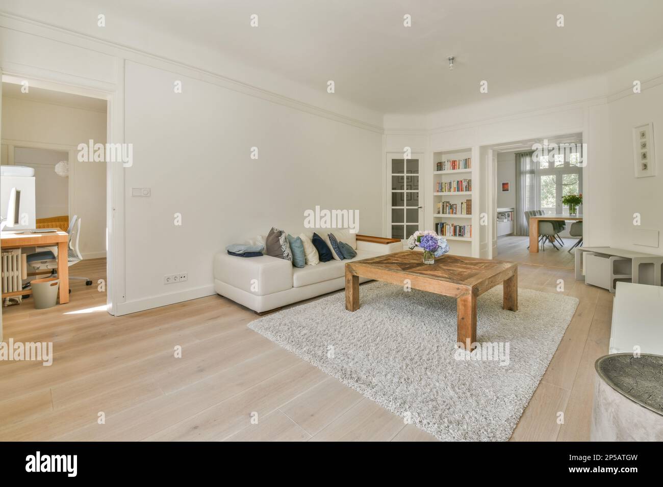 a living room with white walls and hardwood flooring the room is well ...