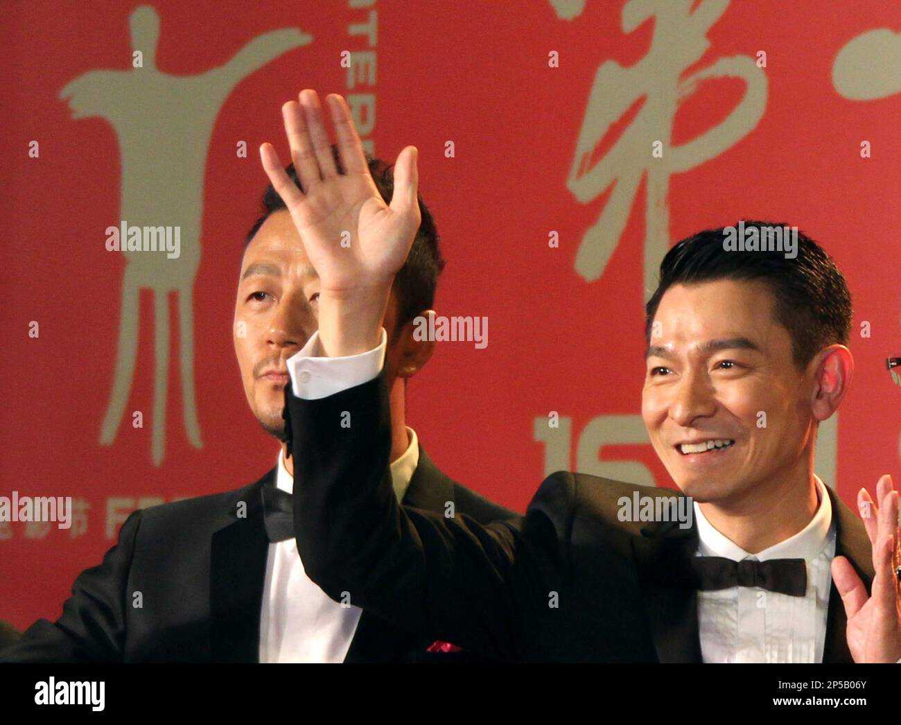 Hong Kong actor Andy Lau, right, waves next to Chinese actor Guo Tao ...