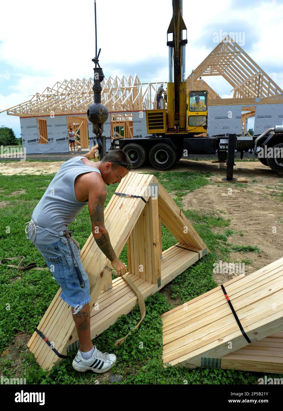 Jake Fogle with Payne Construction and Remodeling LLC, attaches a strap ...