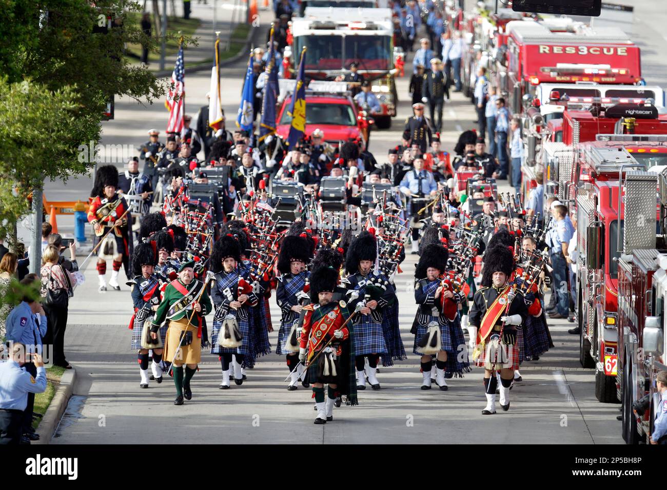 Bagpipers lead firefighters and others in march to a memorial service honoring four Houston ...