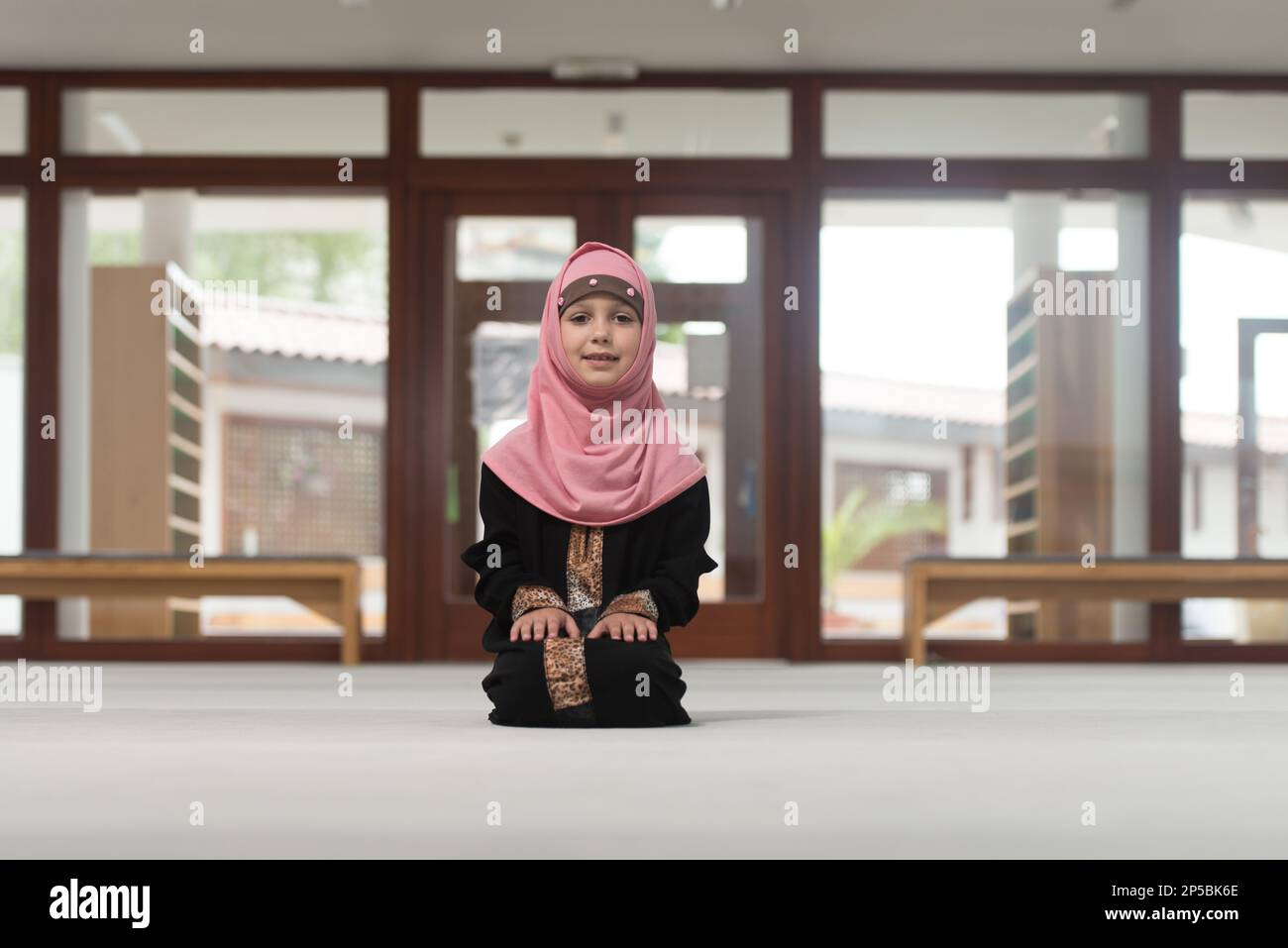 Portrait of a Young Muslim Child Is Praying In The Mosque While Wearing ...