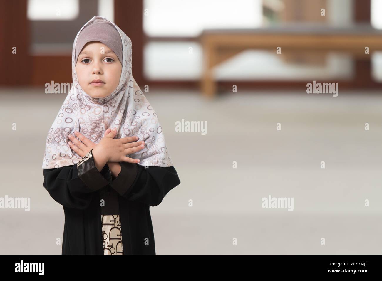 Portrait of a Young Muslim Child Is Praying In The Mosque While Wearing ...