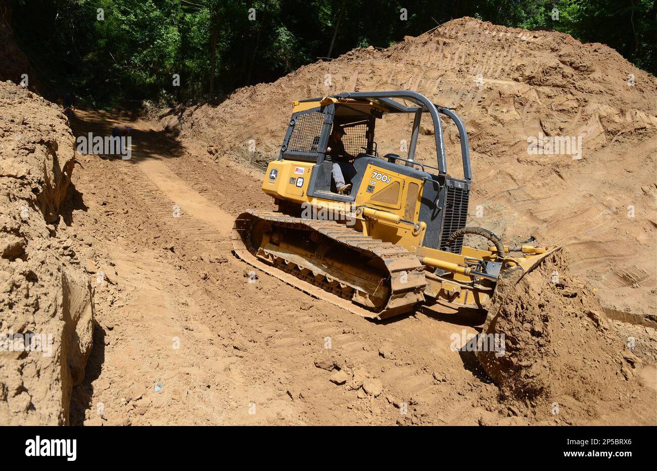 In this May 28, 2013 photo, Ryan Beach uses a bulldozer to clear dirt ...