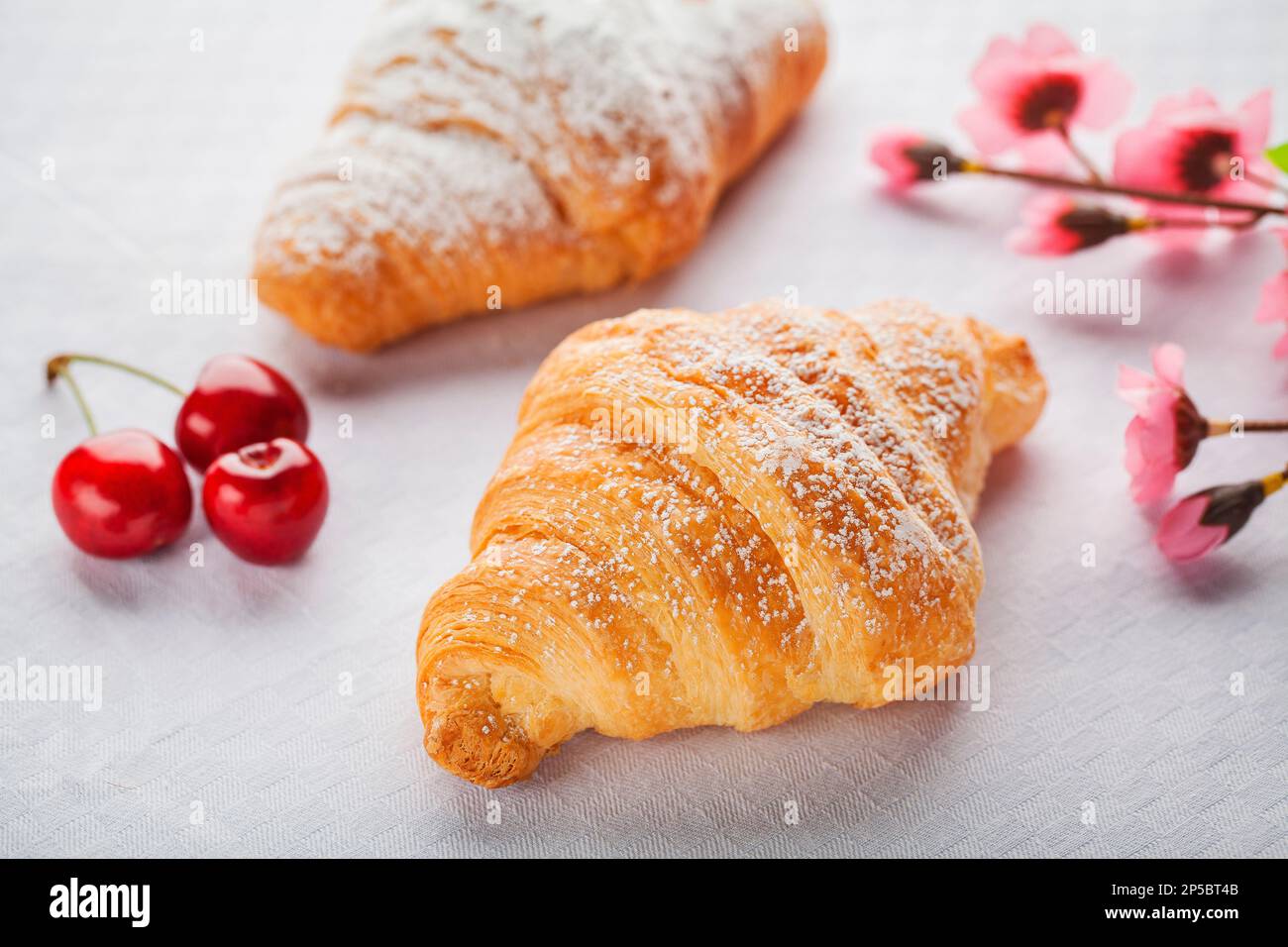 Croissant with sugar candy, cherry jam filling. Typical morning ...
