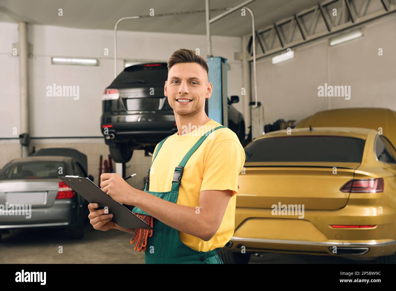 Professional mechanic filling acceptance form at automobile repair shop ...