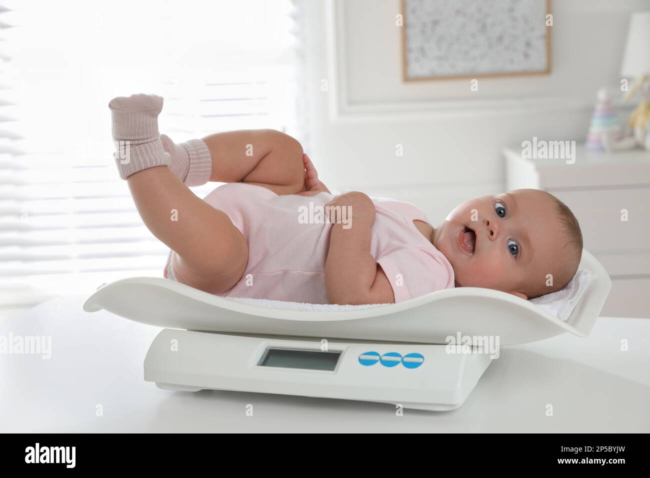 Cute little baby lying on scales at home Stock Photo - Alamy