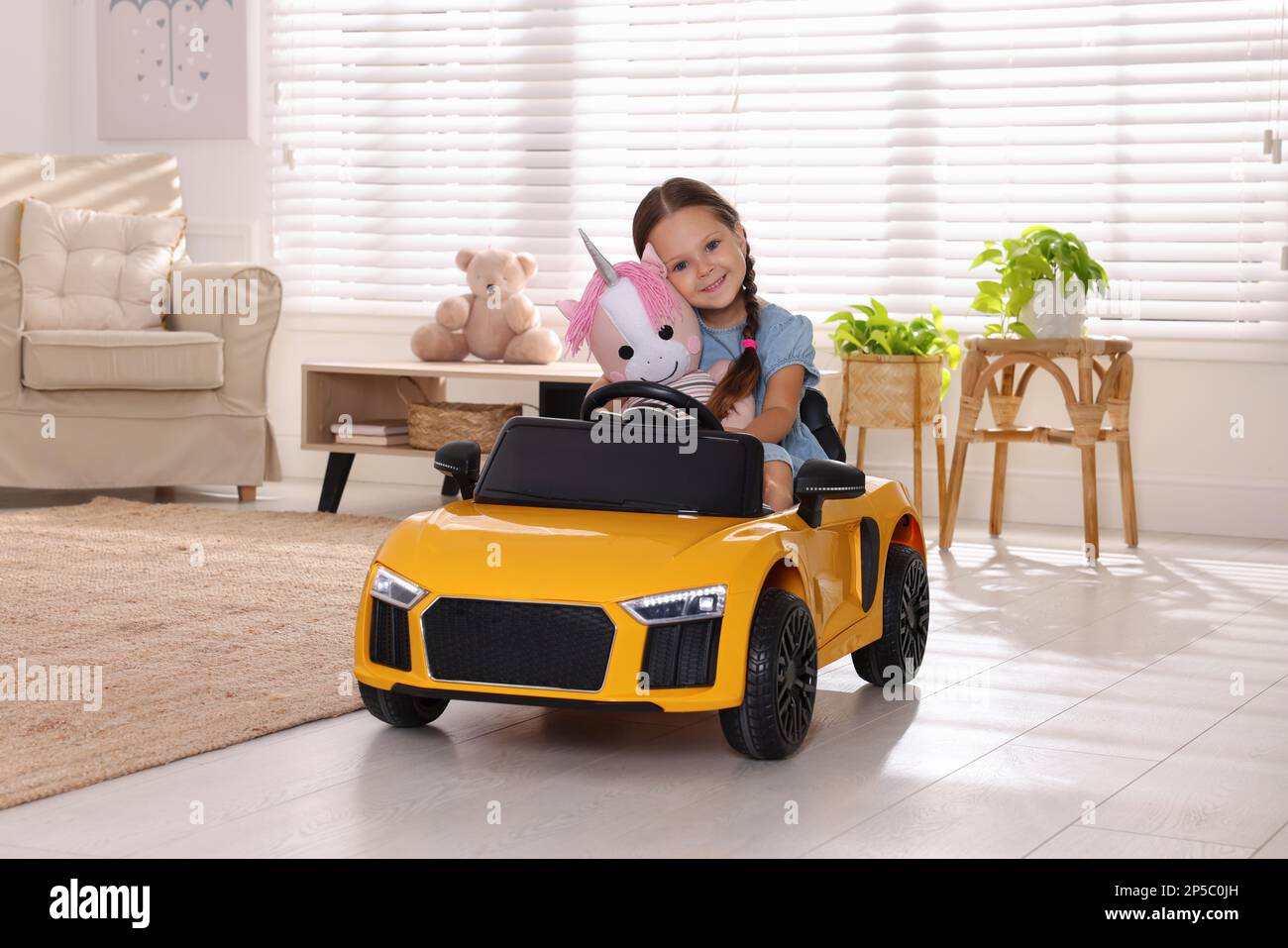 Adorable child with toy driving car in room at home Stock Photo - Alamy