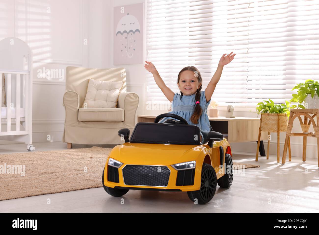 Adorable child driving toy car in room at home Stock Photo - Alamy