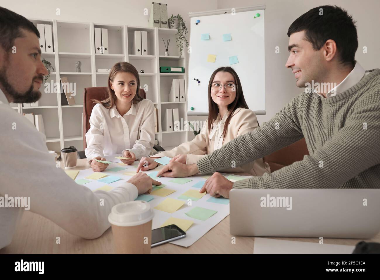 Group of people with sticky notes working on business plan at table in ...