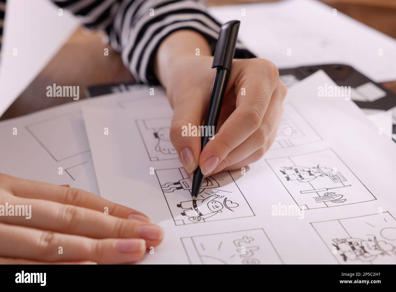 Woman drawing cartoon sketch at workplace, closeup. Pre-production ...