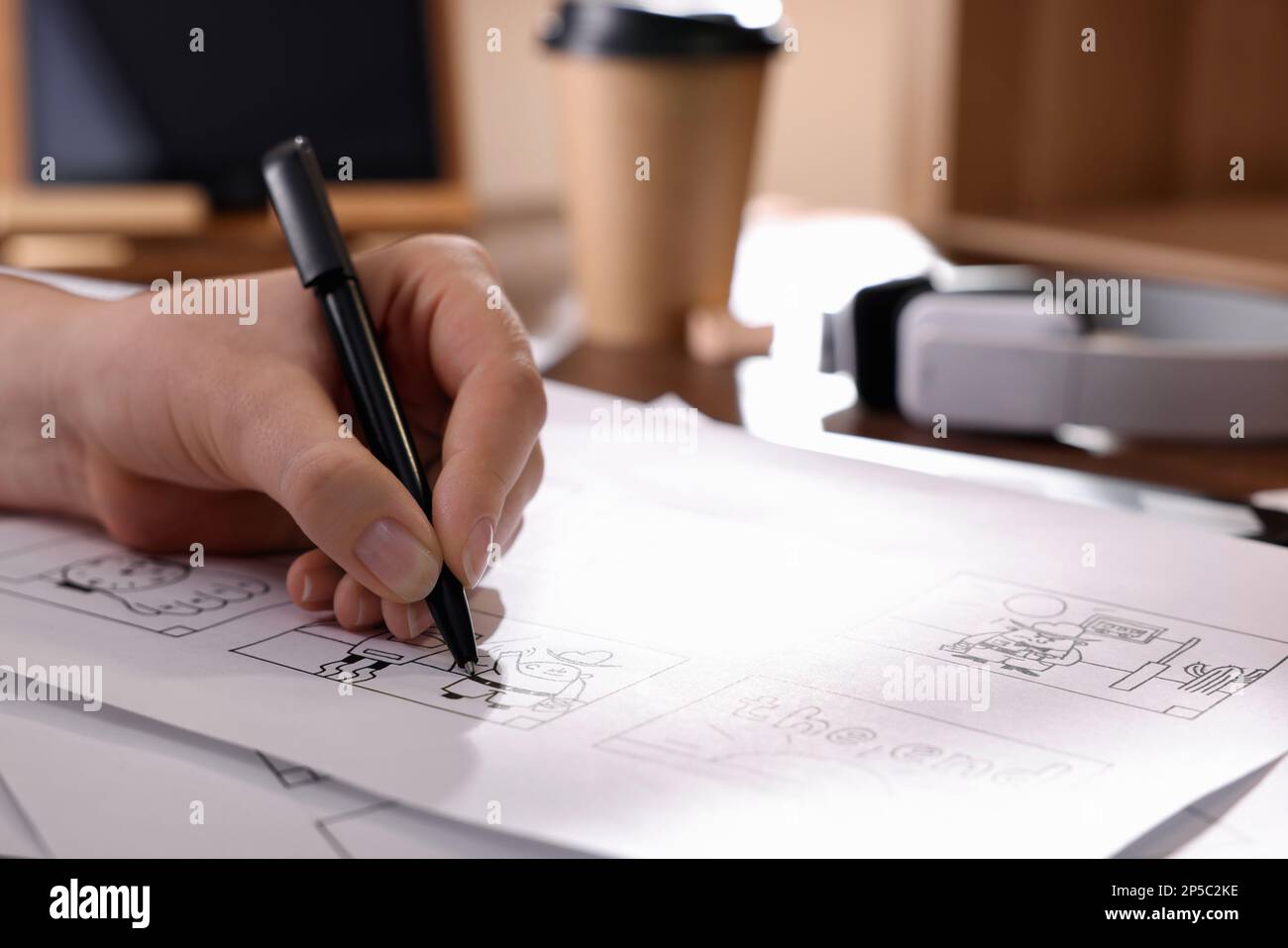 Woman drawing cartoon sketch at workplace, closeup. Pre-production ...