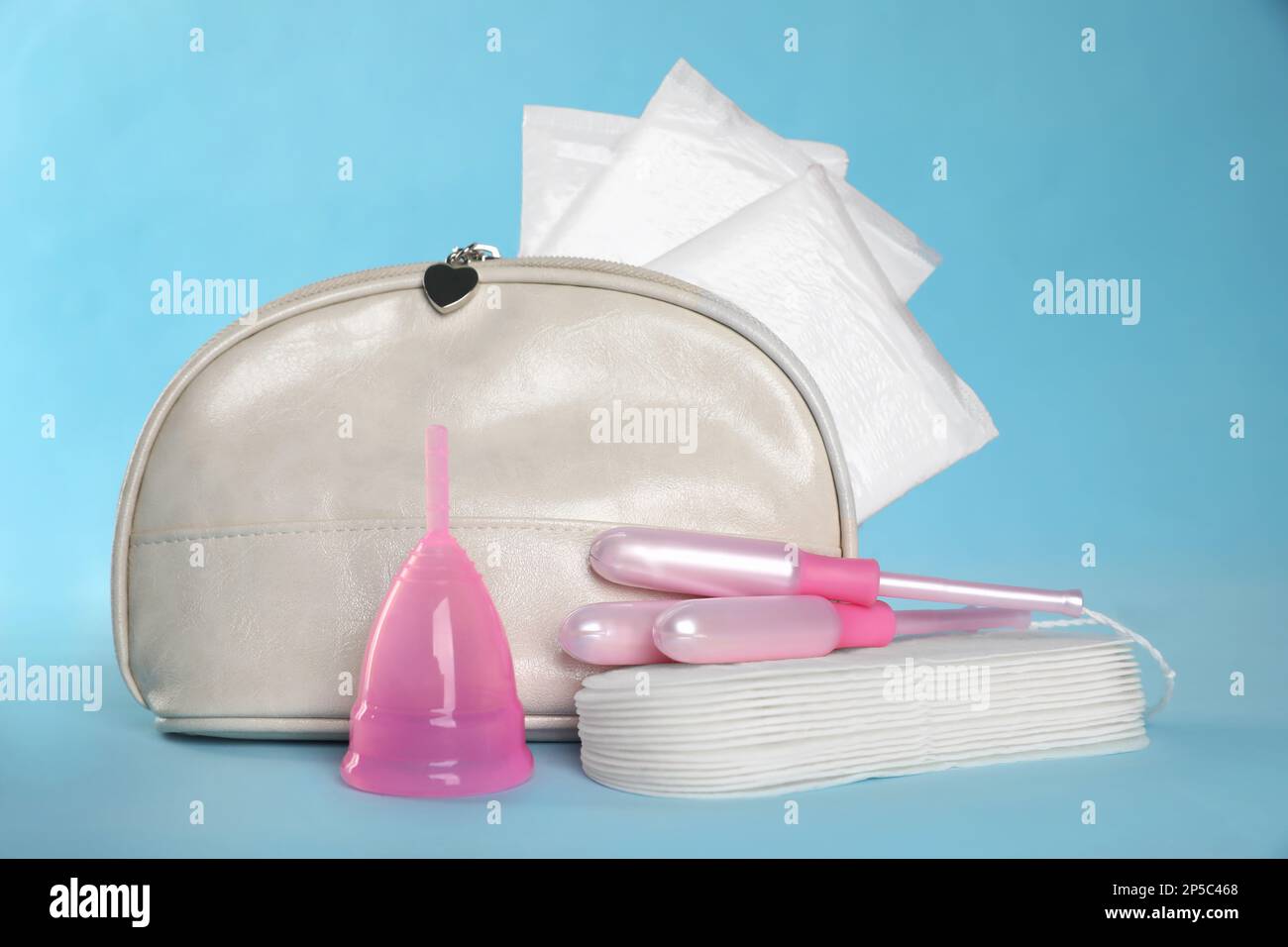 Bag with menstrual pads and other hygiene products on light blue ...