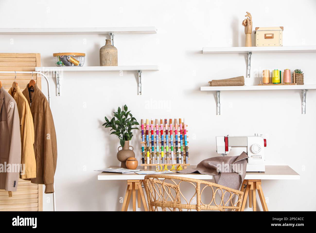 Interior of modern atelier with tailor's workplace, thread spools and shelves Stock Photo - Alamy