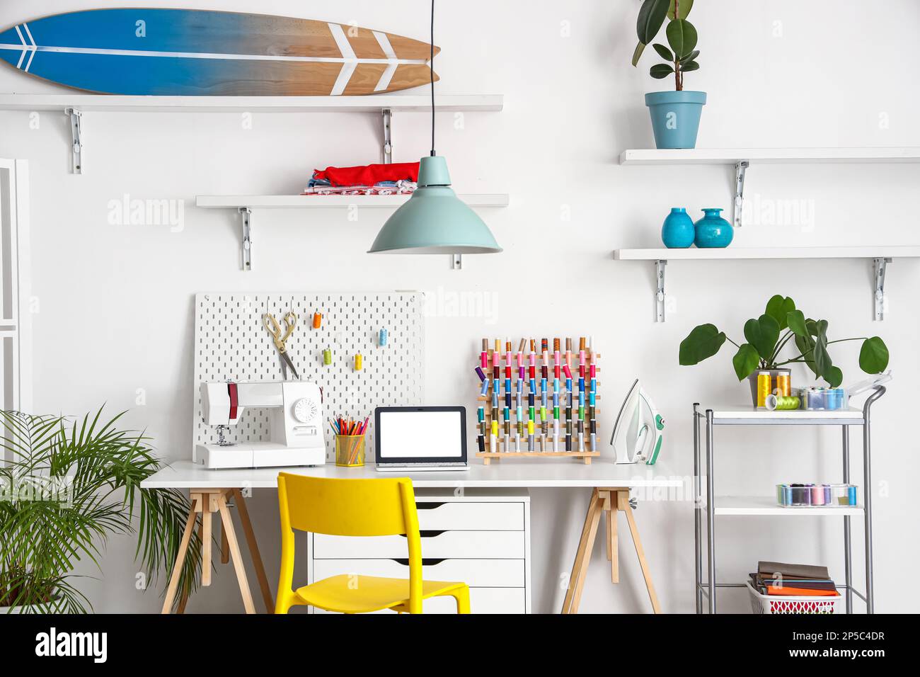 Interior of modern atelier with tailor's workplace, shelves and ...